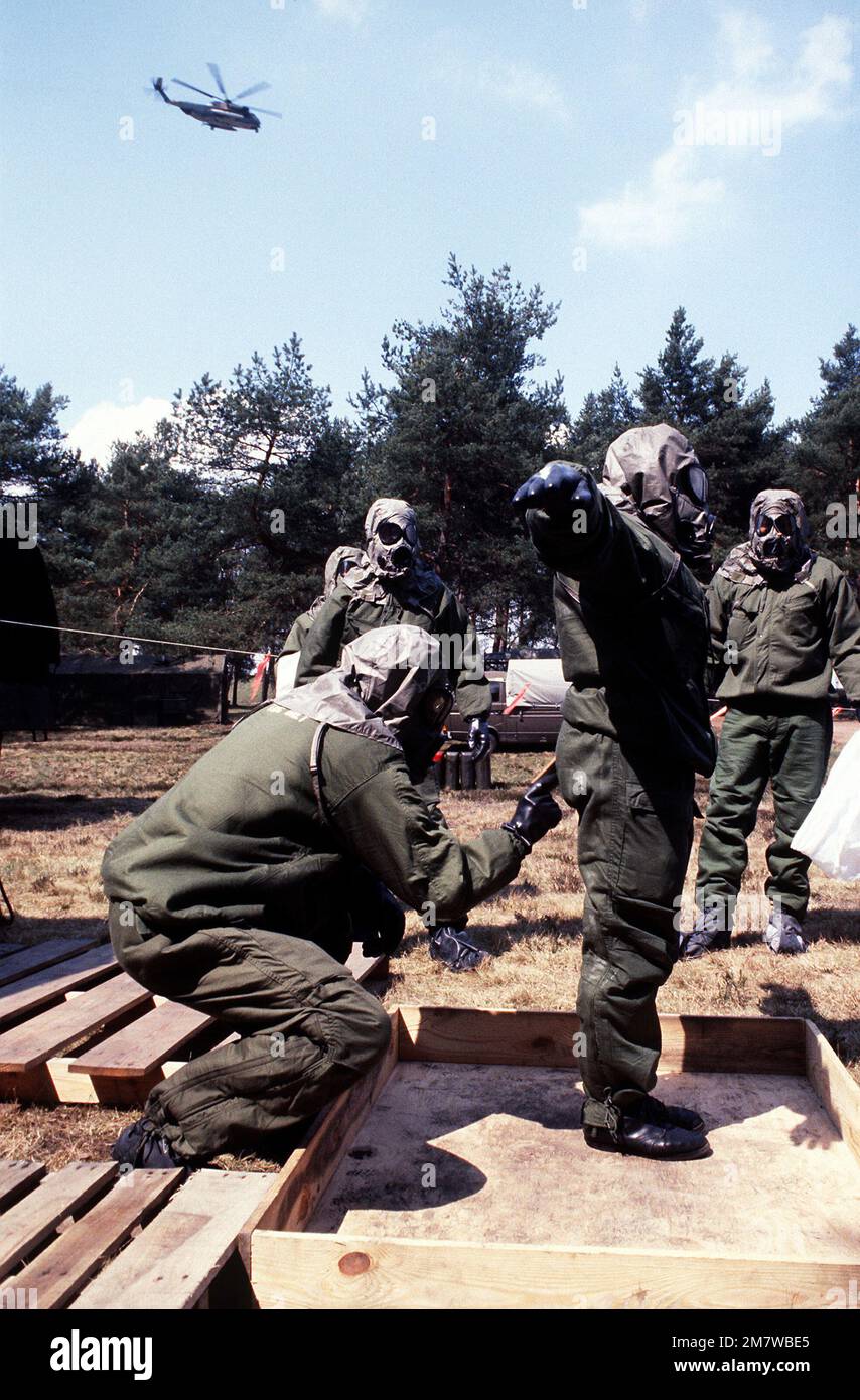 A participant of Exercise UREX '82, wearing chemical warfare gear, is ...