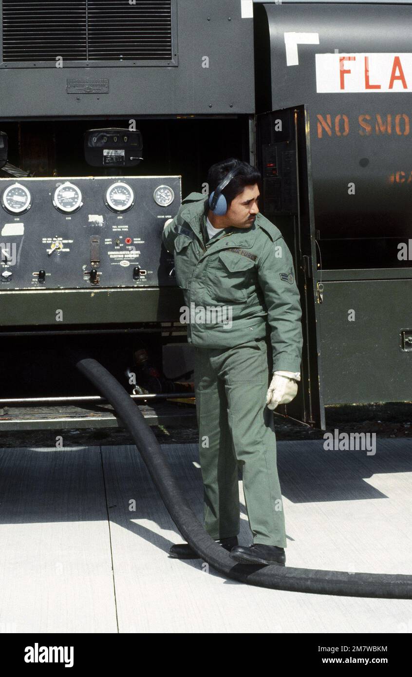 A ground crewman monitors the gauges on a fuel truck, as hot pit ...