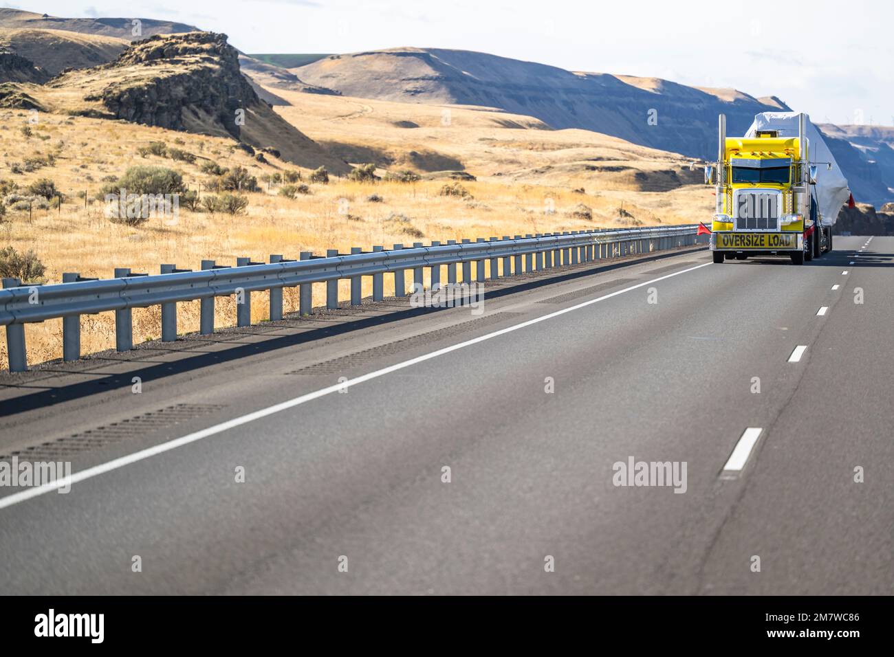 Industrial yellow classic big rig semi truck tractor with oversize load ...