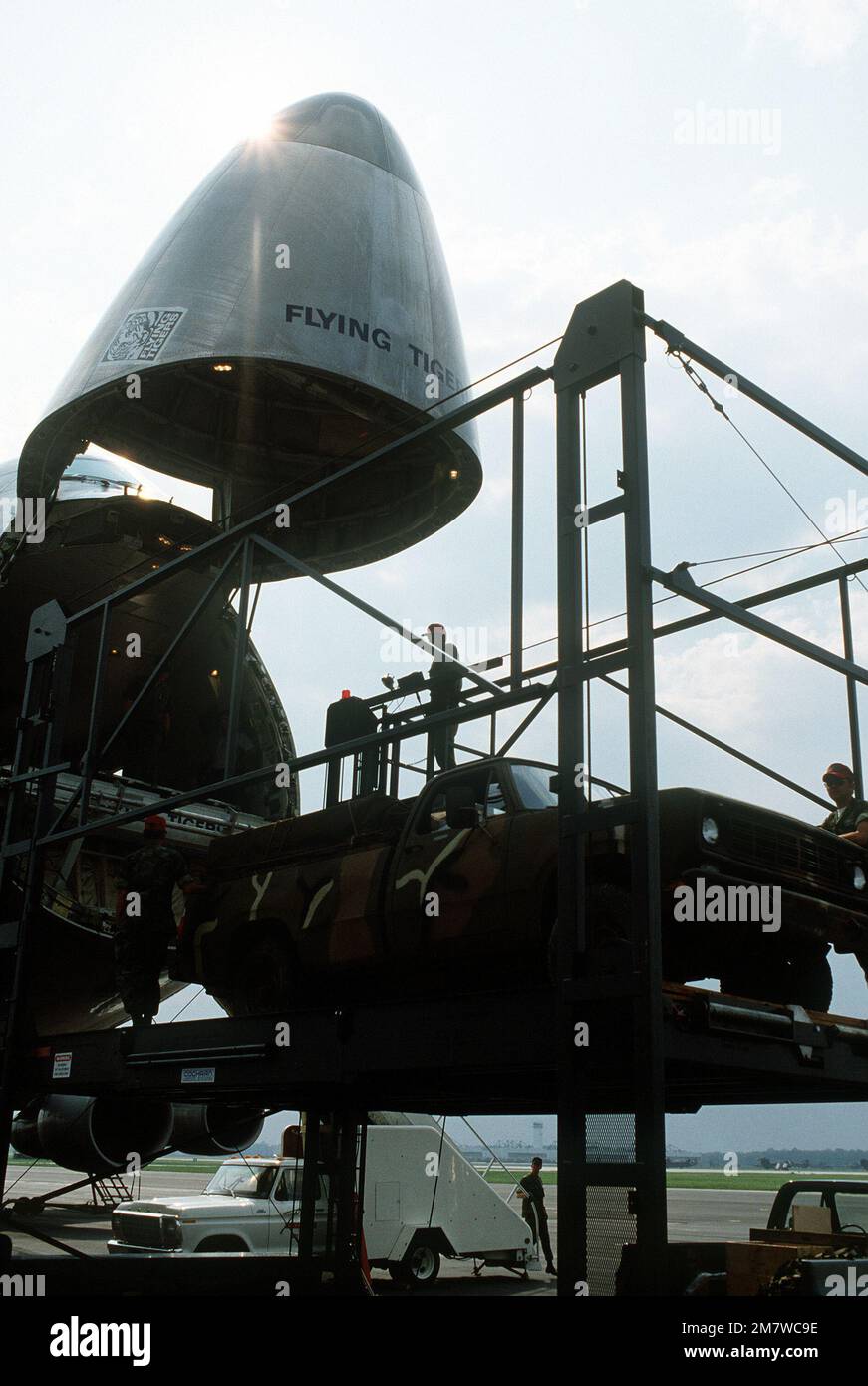 A right front view of a 747 cargo aircraft as a pick-up truck is ...