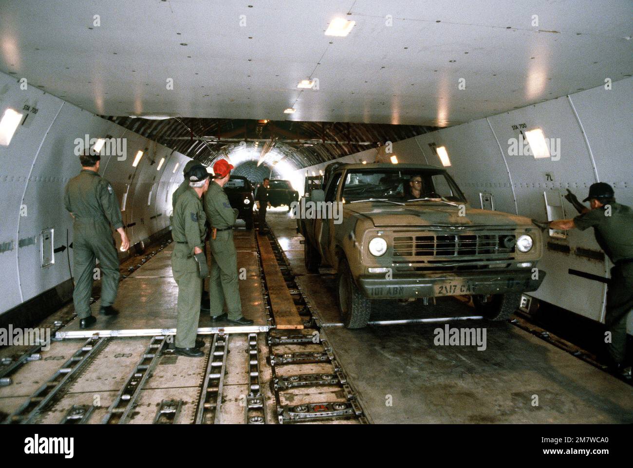 An interior view of a 747 cargo aircraft with pick-up trucks being ...