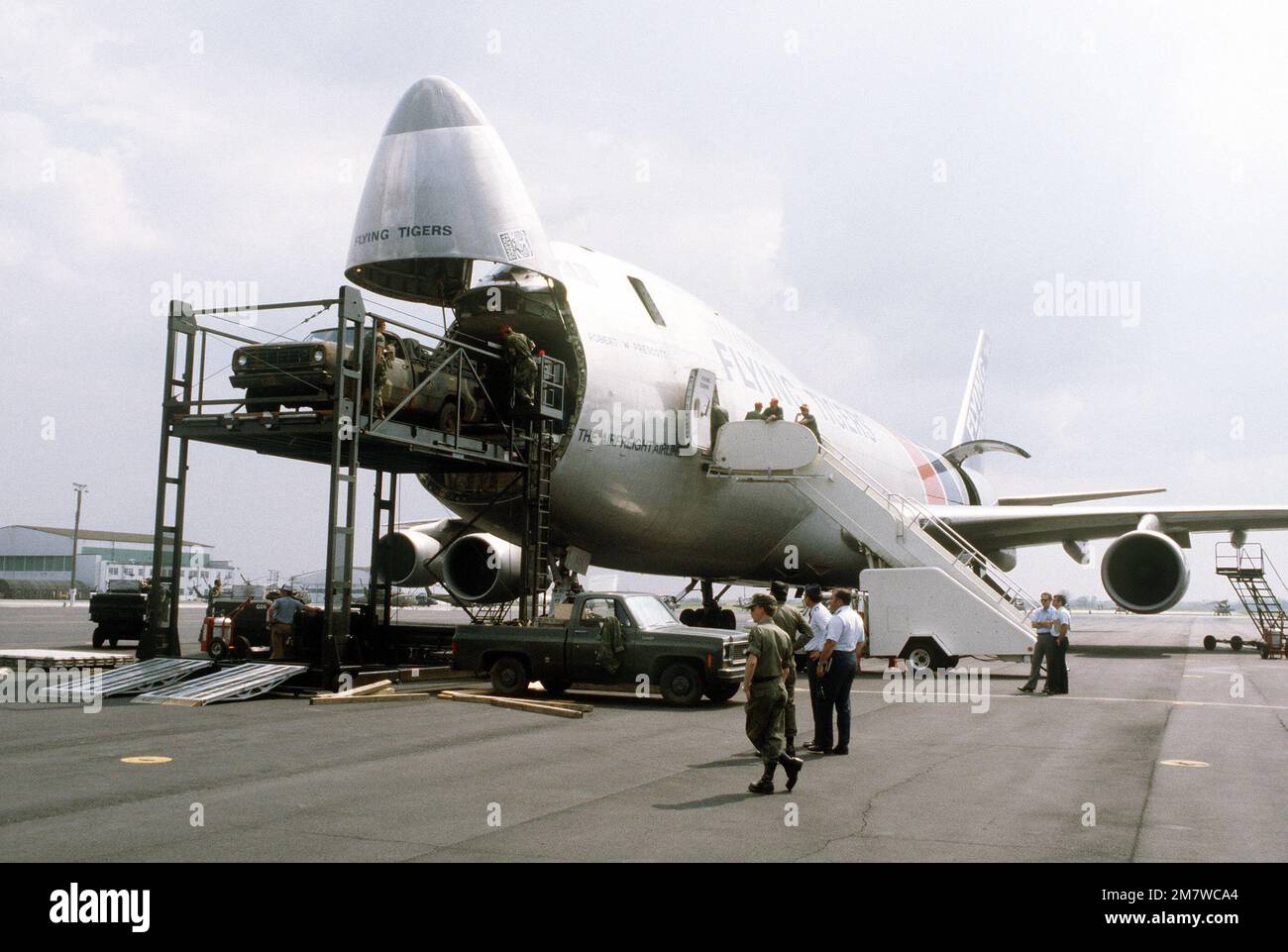 A left front view of a 747 cargo aircraft as a pick-up truck is ...