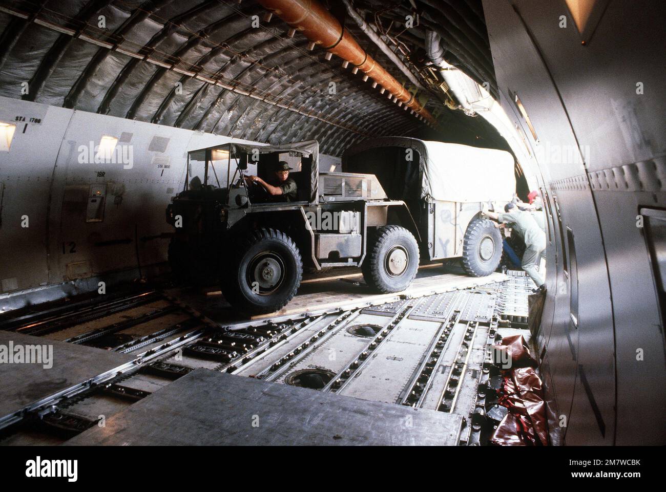 An interior view of a 747 cargo aircraft as a vehicle with a trailer is ...
