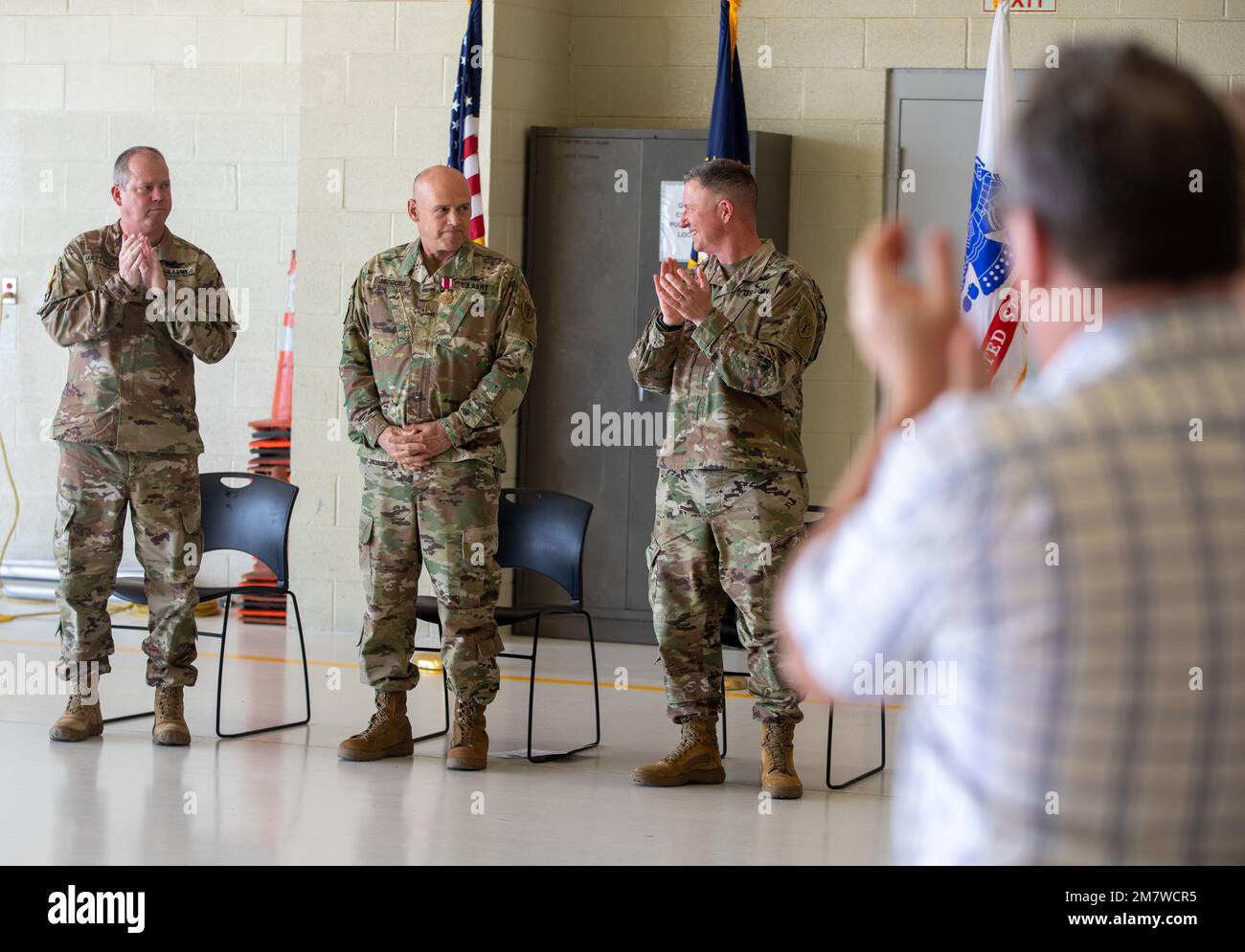 Chief Warrant Officer 5 Daniel Jacques (center), receives a standing ...