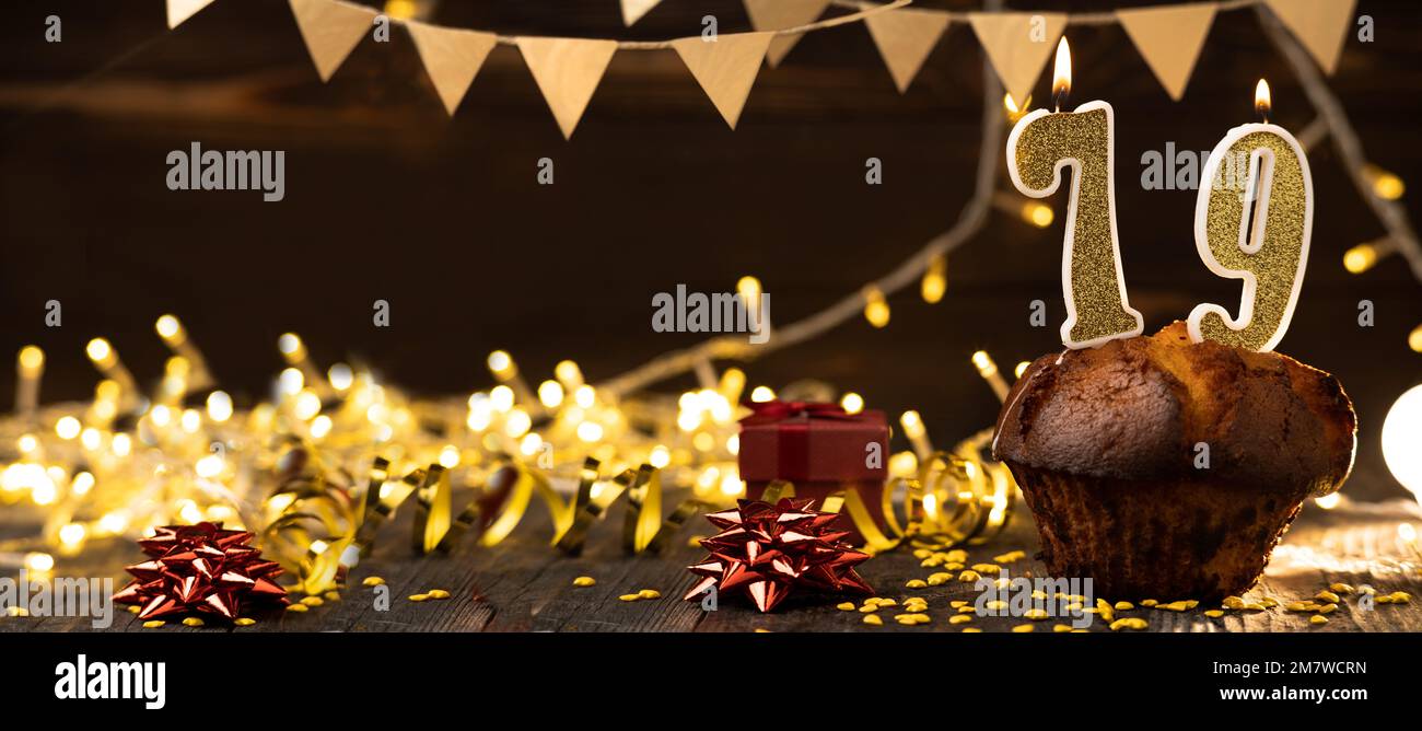 Number 79 golden festive burning candles in cake, wooden holiday ...