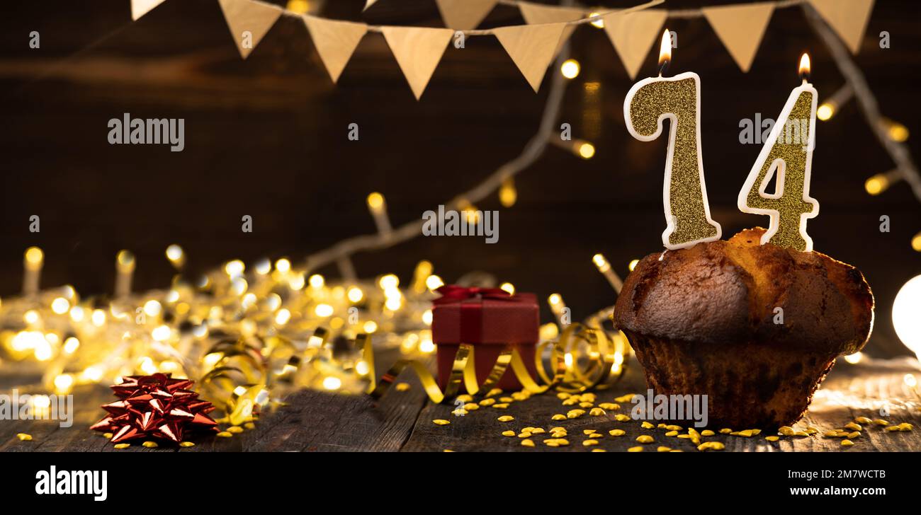 Number 74 golden festive burning candles in cake, wooden holiday ...