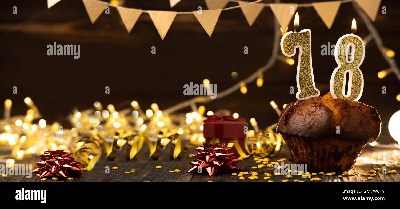 Number 78 golden festive burning candles in a cake, wooden holiday ...