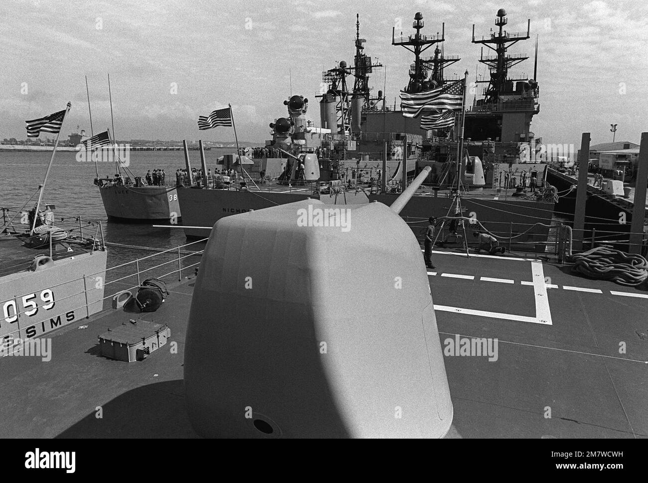 A stern view of three U.S. Navy ships tied at the dock during a port ...