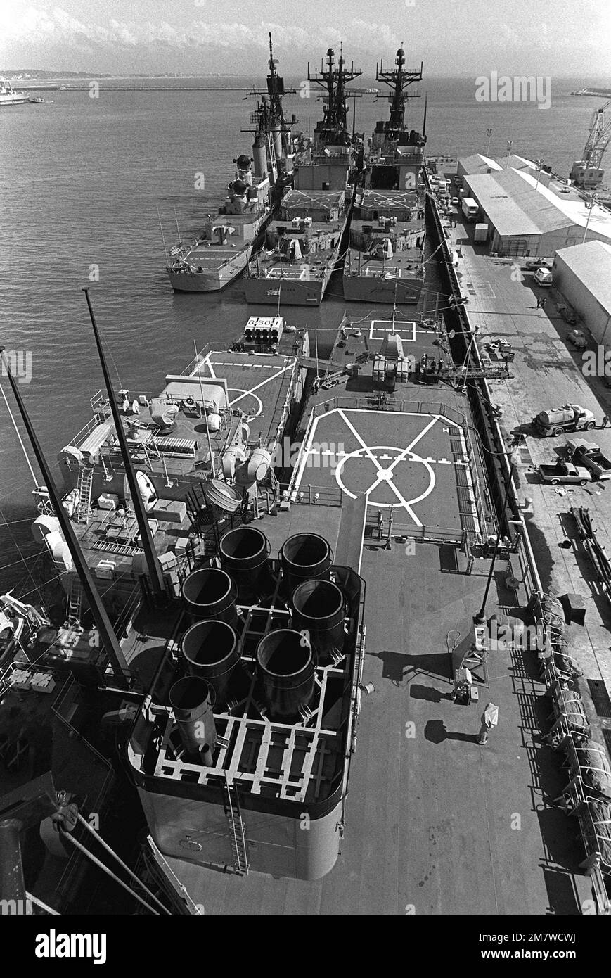 A stern view of three U.S. Navy ships tied at the dock during a port ...