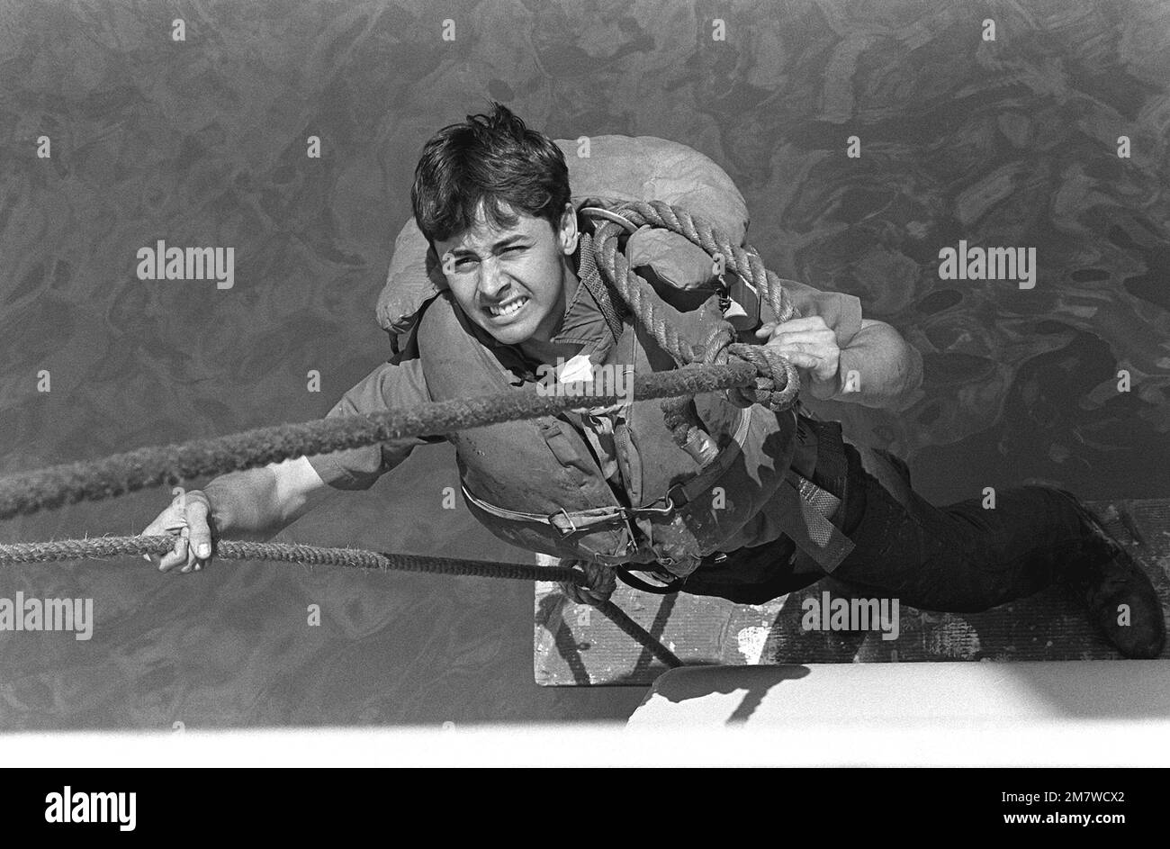 A crewman aboard the destroyer USS JOHN RODGERS (DD-983) is lowered ...