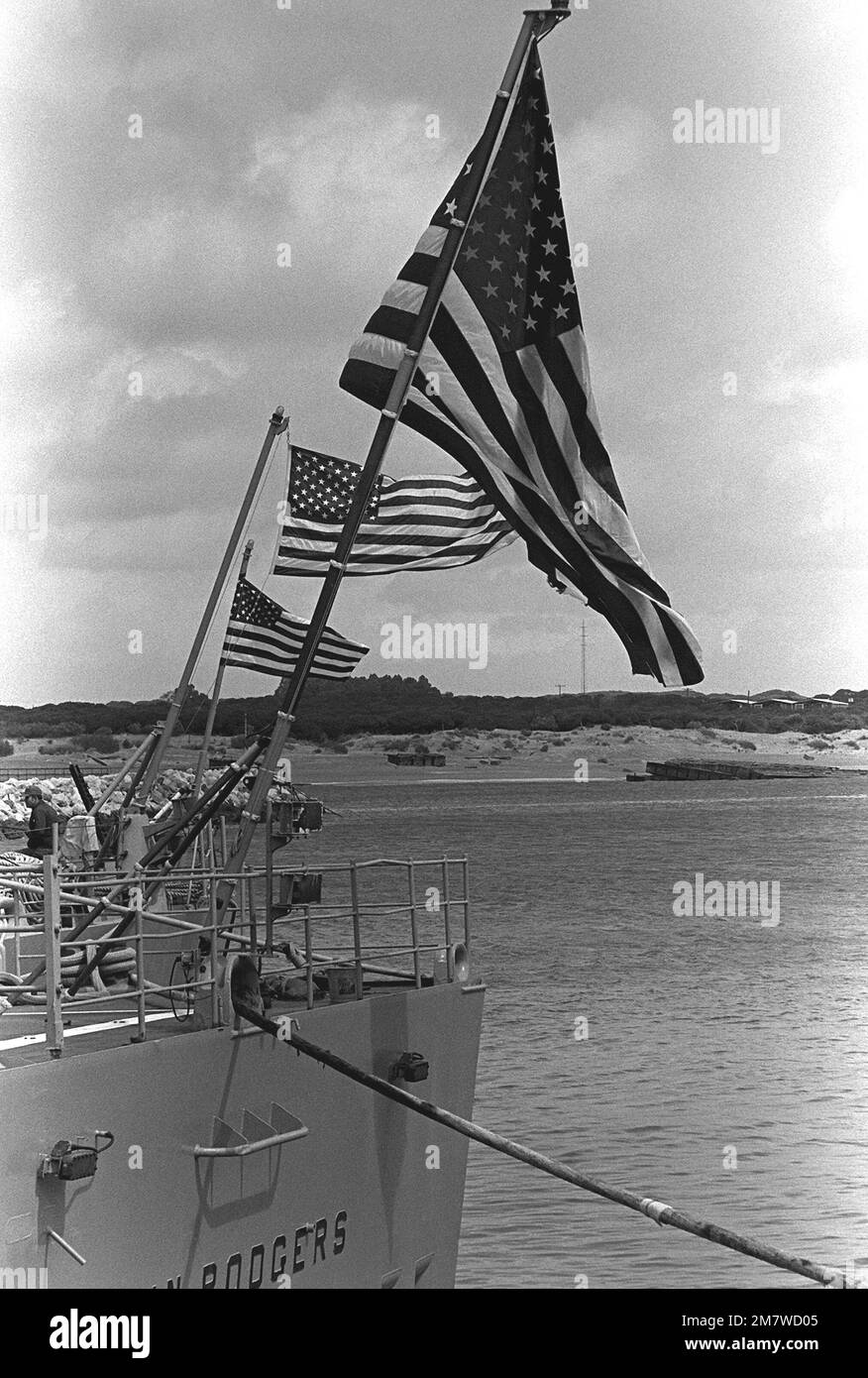 United States flags, positioned at the stern of docked ships, flutter ...