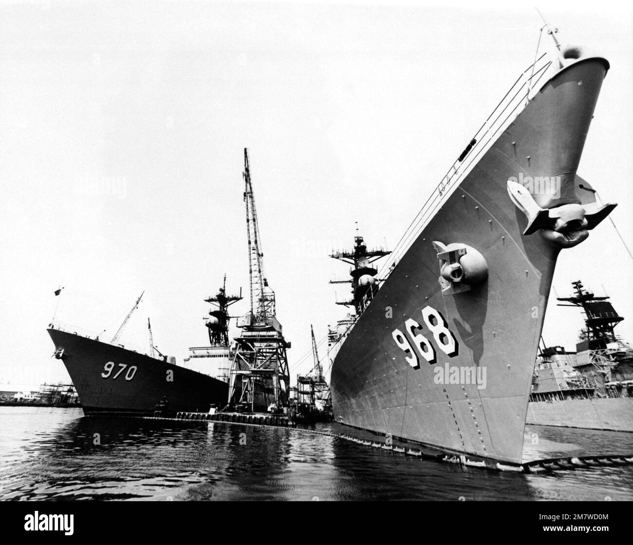 Two Spruance class destroyers in dry dock. To the right, a starboard ...