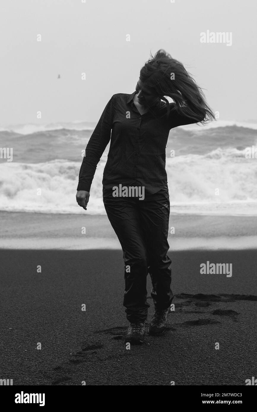 Traveler walking along on Reynisfjara beach monochrome scenic ...