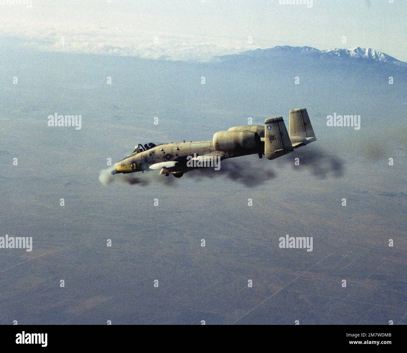 An air-to-air left side view of an A-10 Thunderbolt II aircraft firing ...