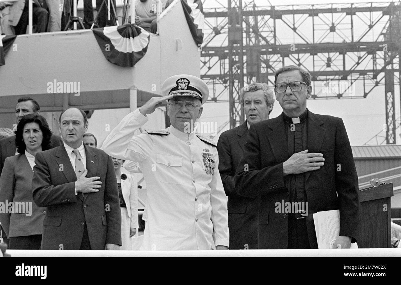 Guest speakers stand for the national anthem during the launching ...