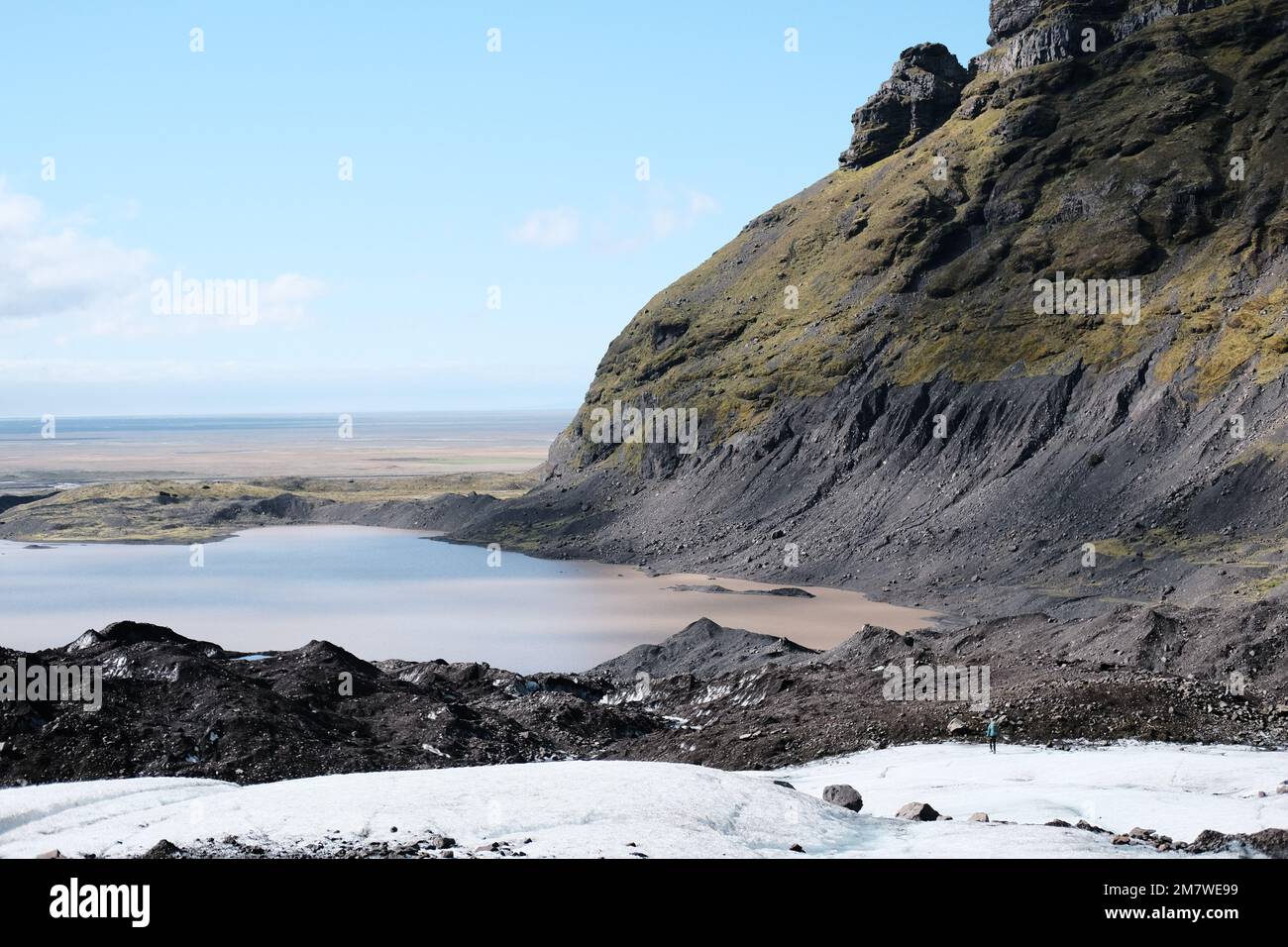 A scenic view of a barren mountain slope against the sea Stock Photo ...