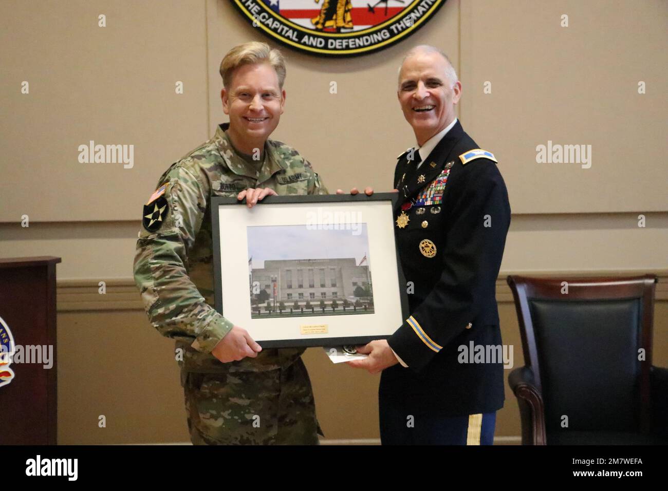 Lt. Col. Paul Dotto (left) assigned to the Multi-Agency Augmentation Command (MAC), presents a ...
