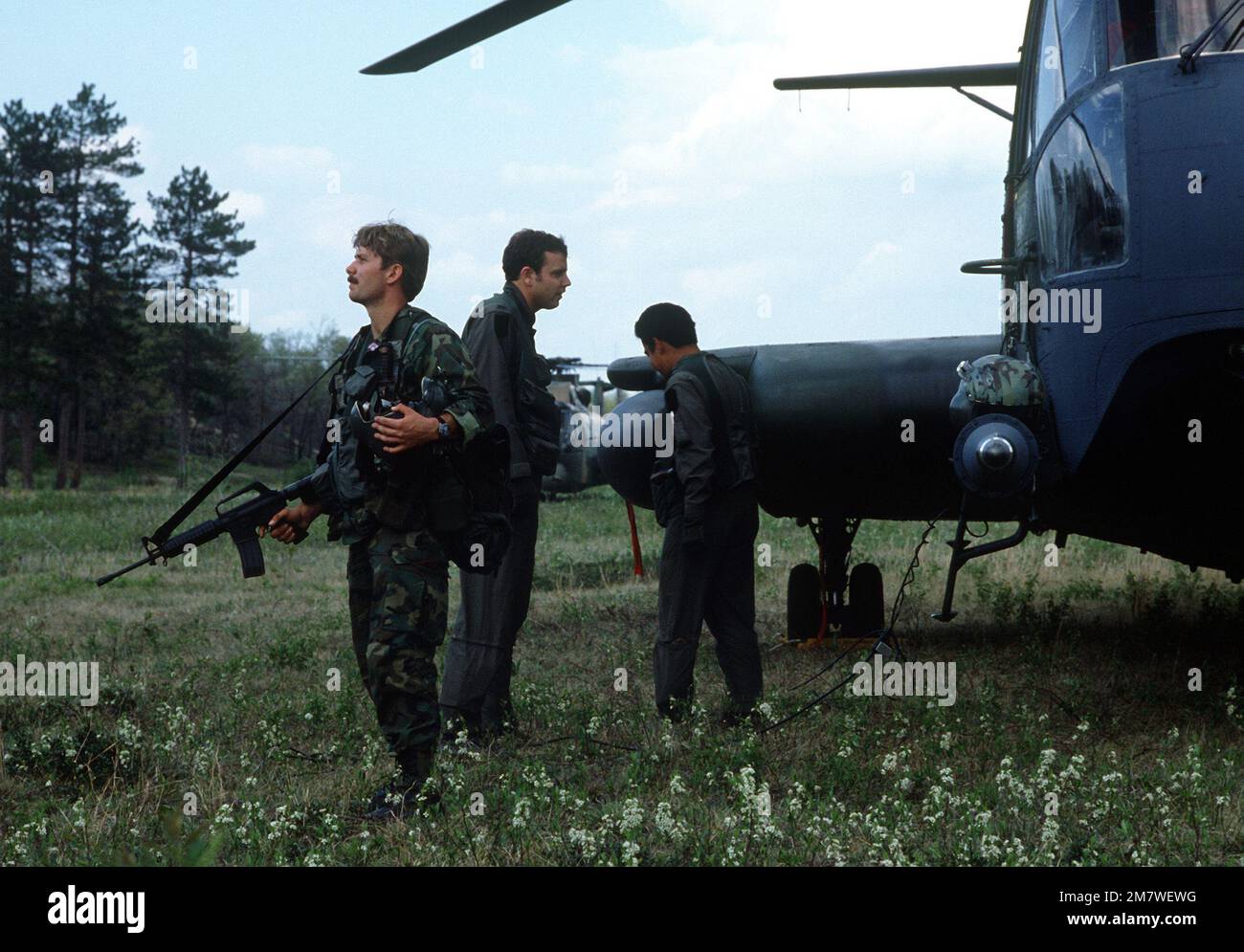 Crewmen armed with M-16A1 rifles, disembark an HH-3E Jolly Green Giant ...