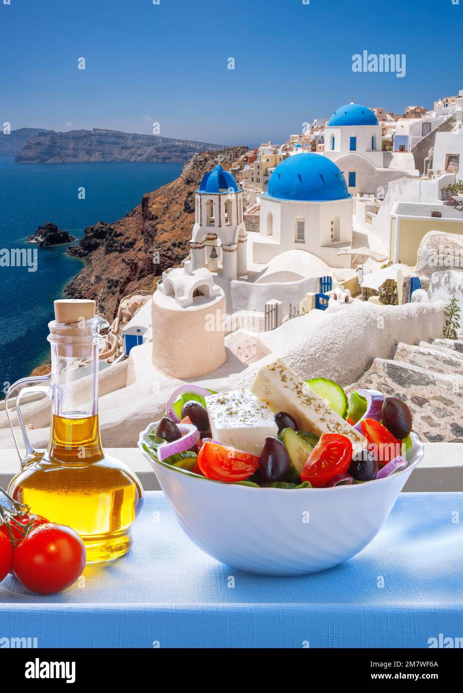 Greek food against famous churches in Oia village on Santorini island ...