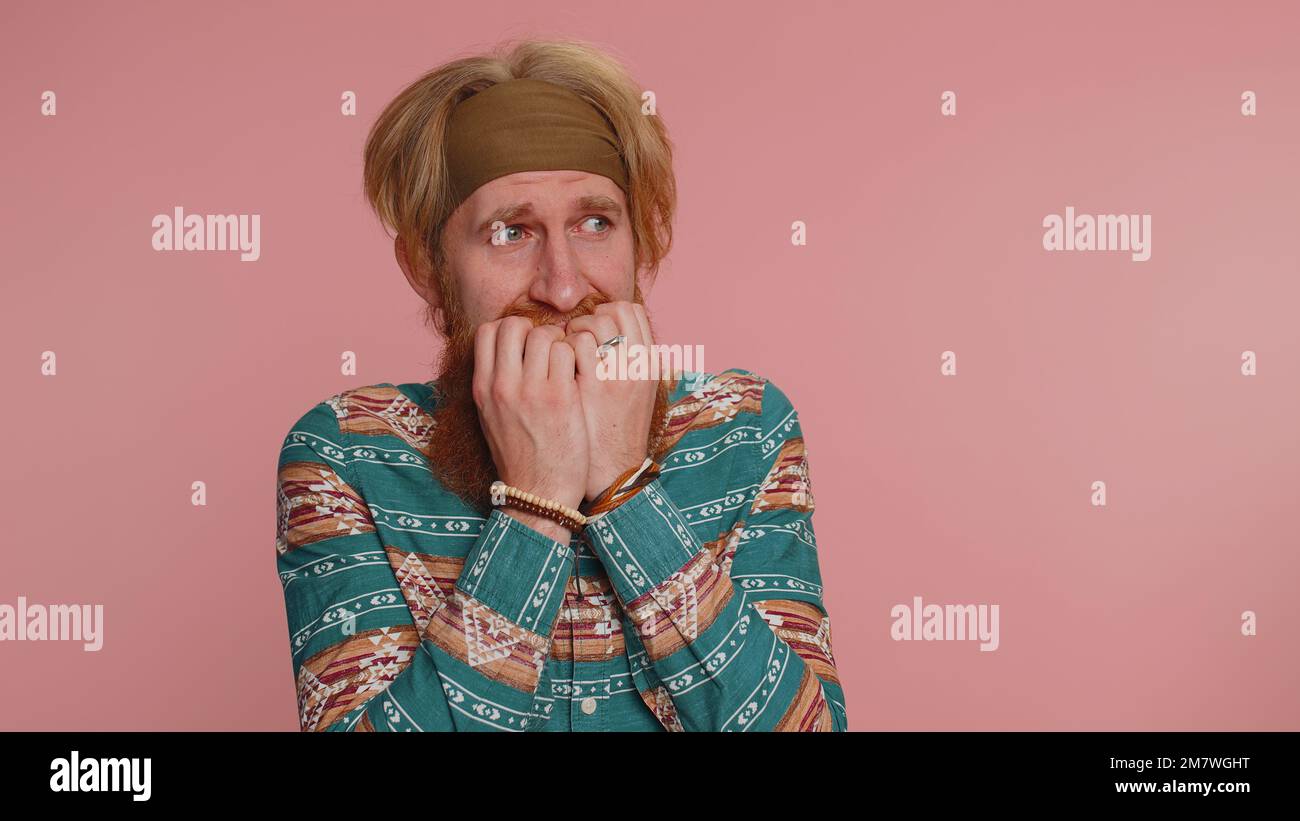 Upset scared frightened hippie redhead bearded man biting nails ...