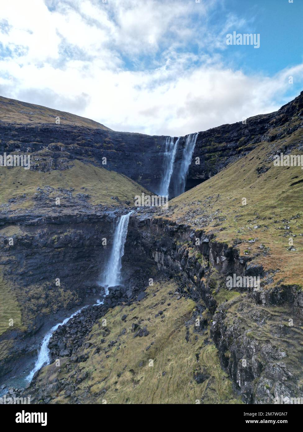 A vertical aerial view of the flowing Fossa Waterfall in the Faroe ...