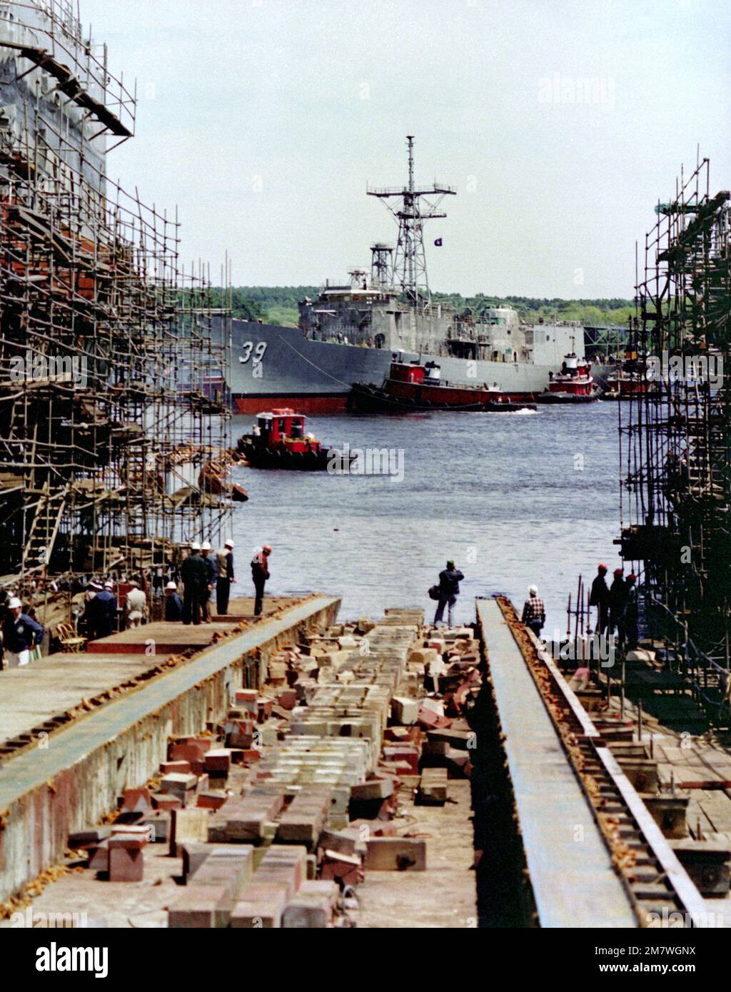 The guided missile frigate DOYLE (FFG-39) is assisted by large harbor ...