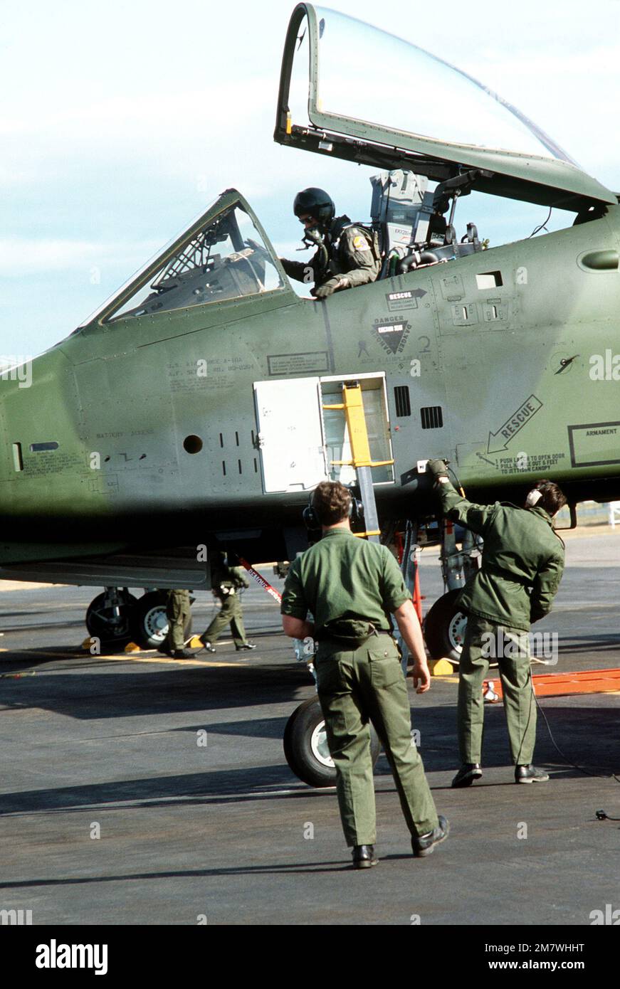 Ground crew members assist a pilot, on board an A-10 Thunderbolt II ...