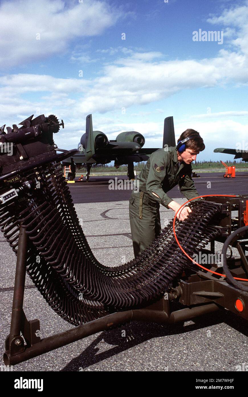 An airman is preparing a loader for loading ammunitions in an A-10 ...