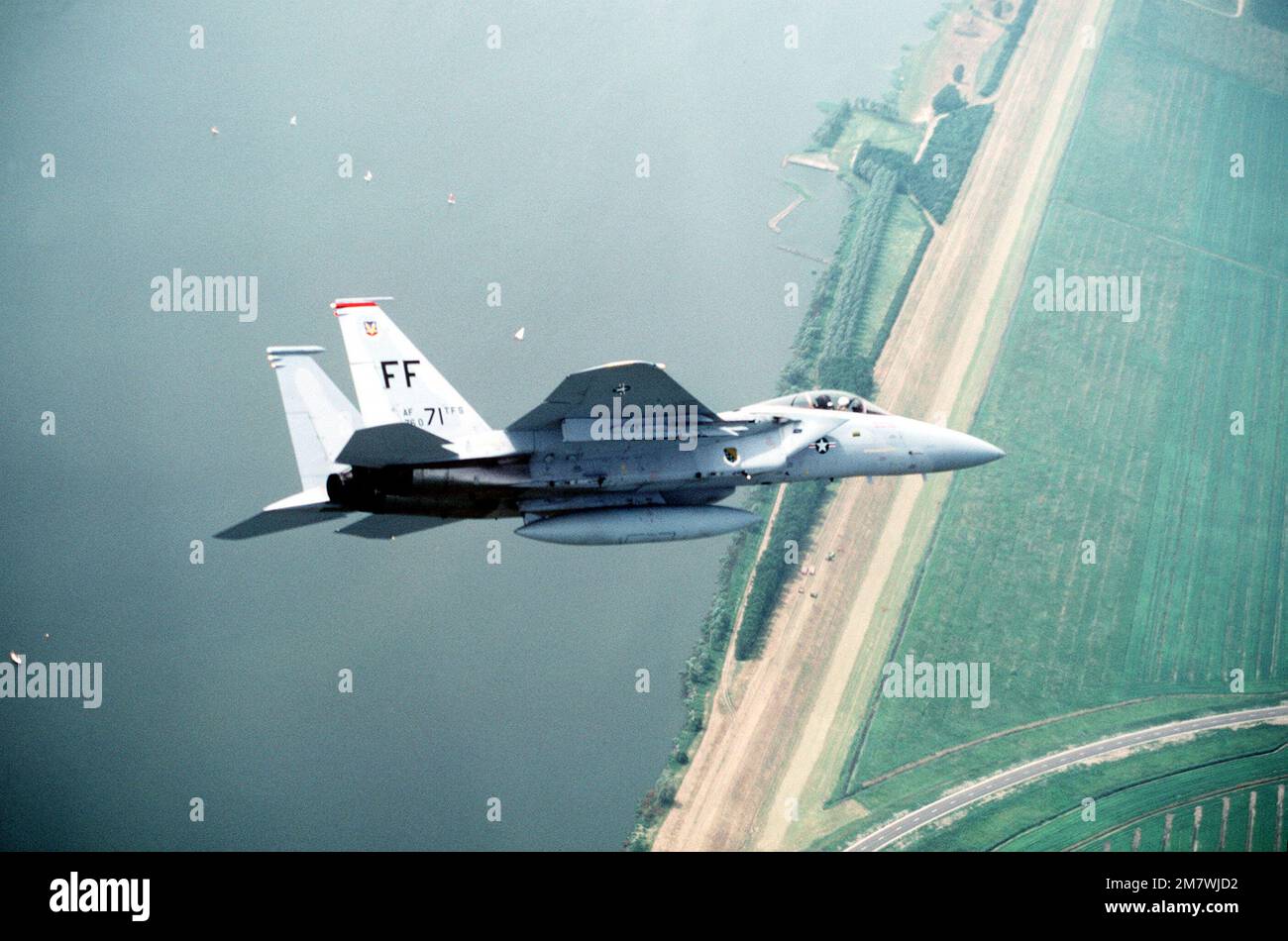 An air-to-air right side view of an F-15A Eagle aircraft in a vertical ...