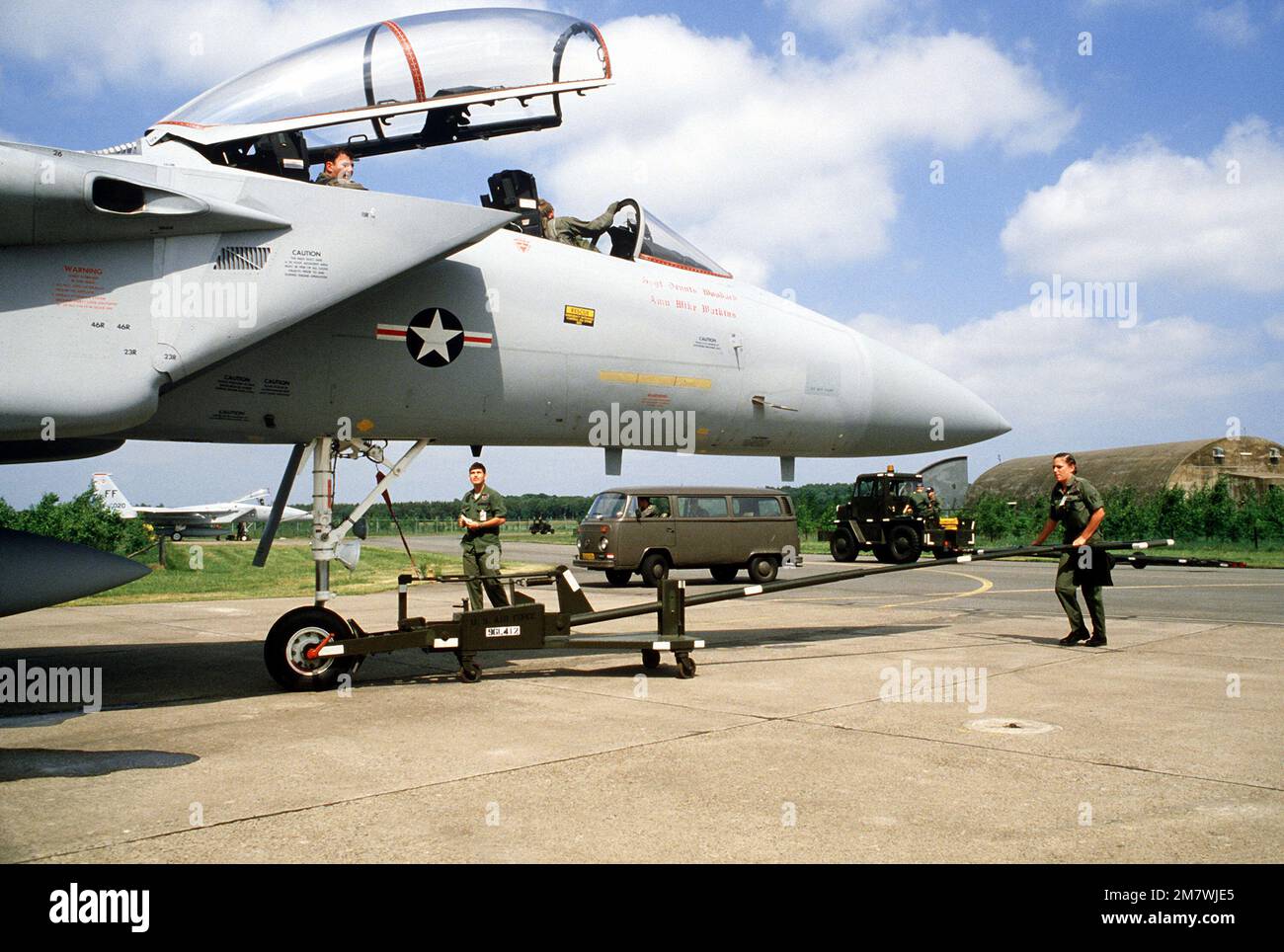 A ground crew member attaches a tow bar to an F-15D Eagle aircraft to ...