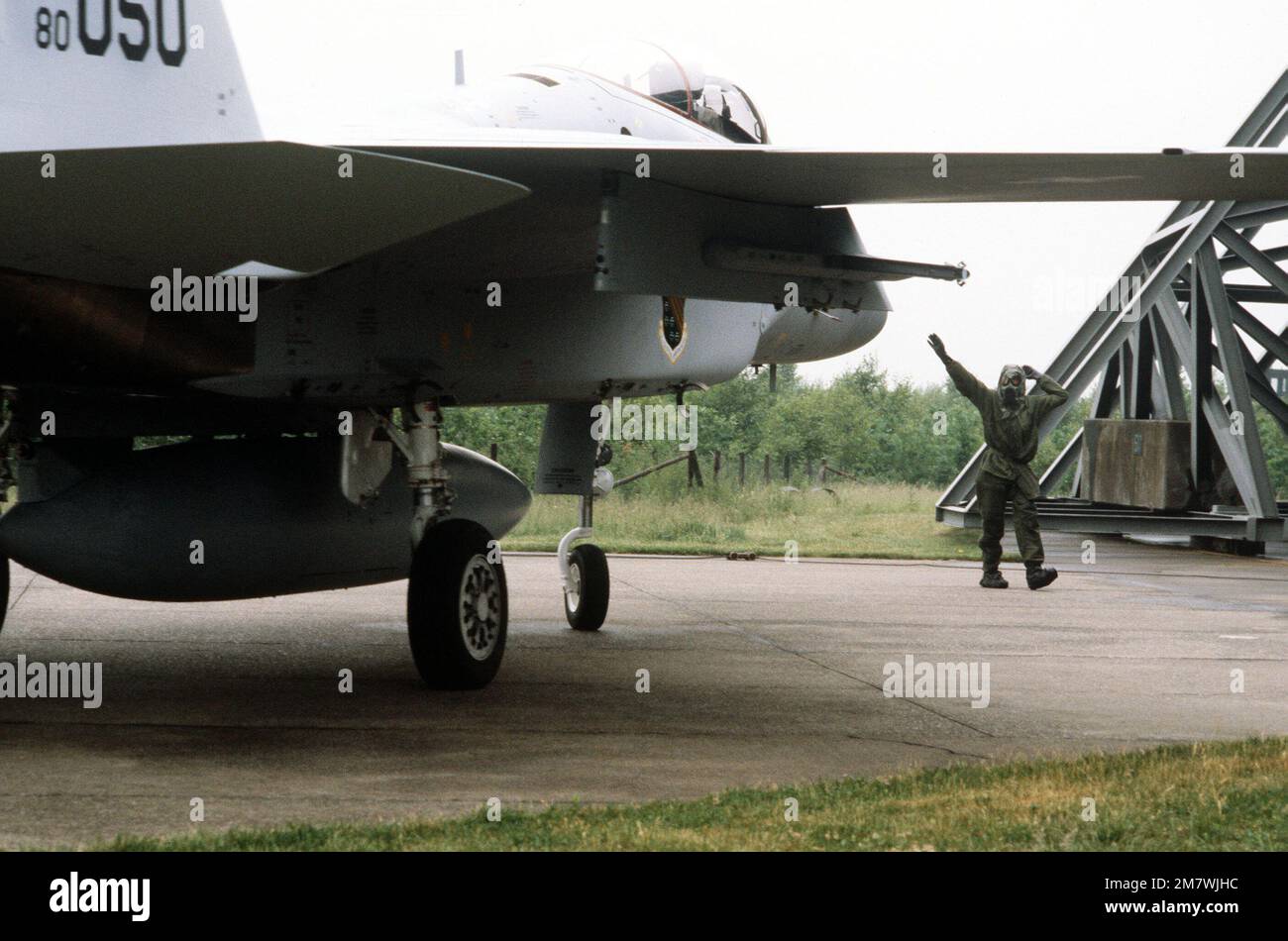A ground crew member marshals an F-15A Eagle aircraft out of a tab-vee ...