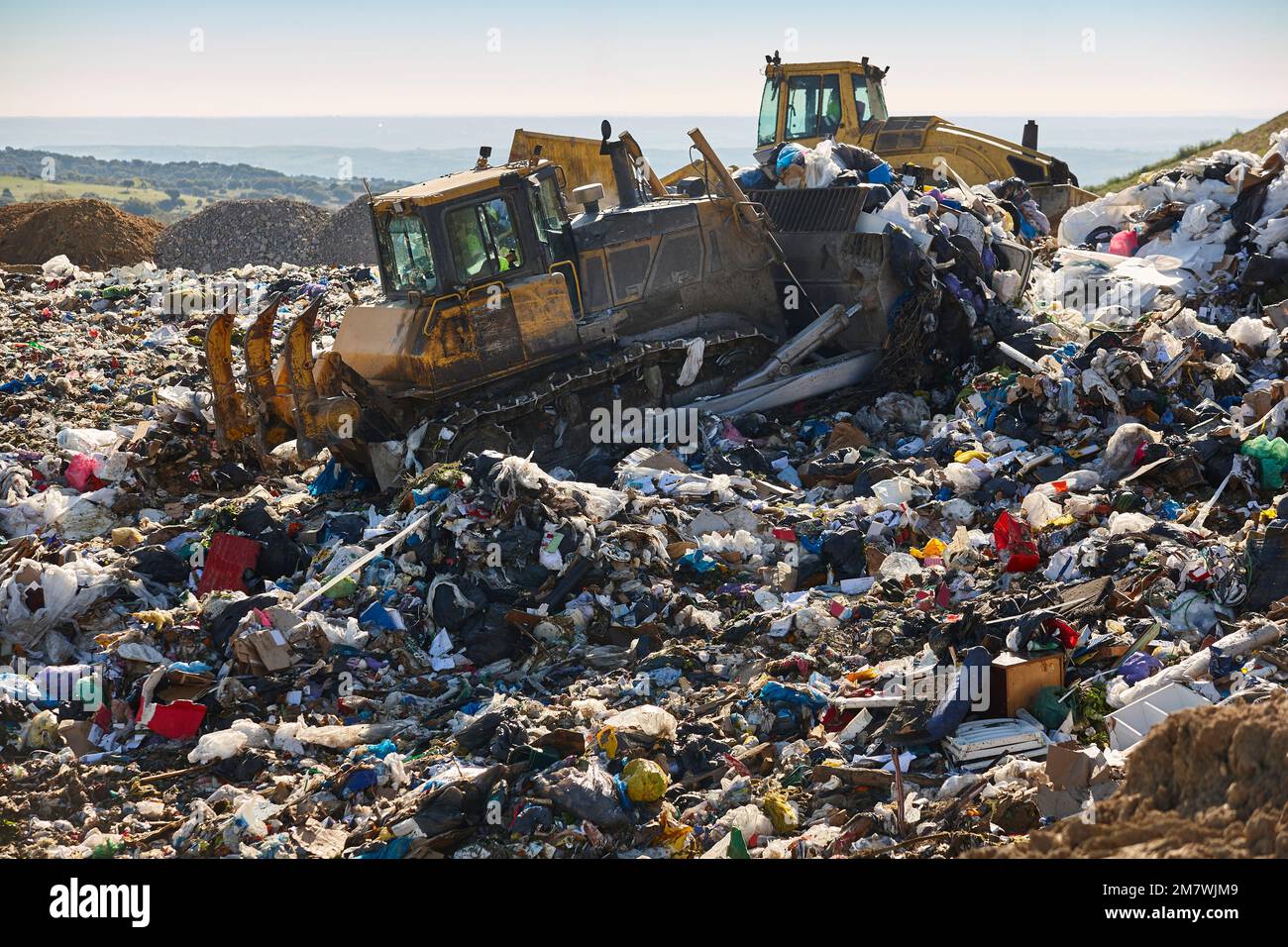 Heavy machinery shredding garbage in an open air landfill. Waste Stock ...