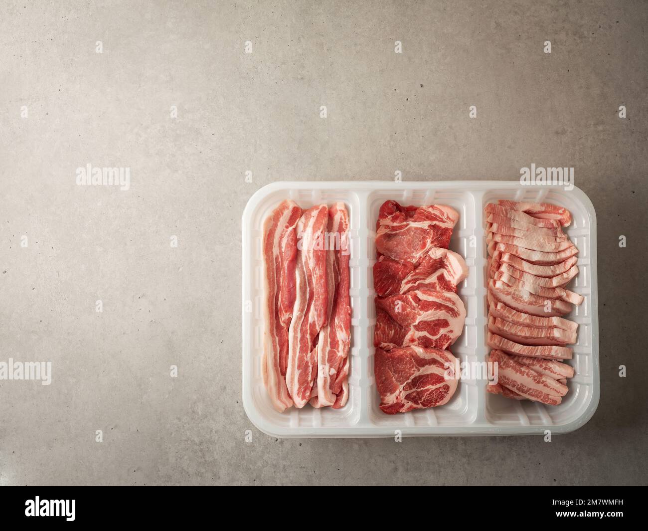 Assorted pork cuts on trays for packaging Stock Photo - Alamy