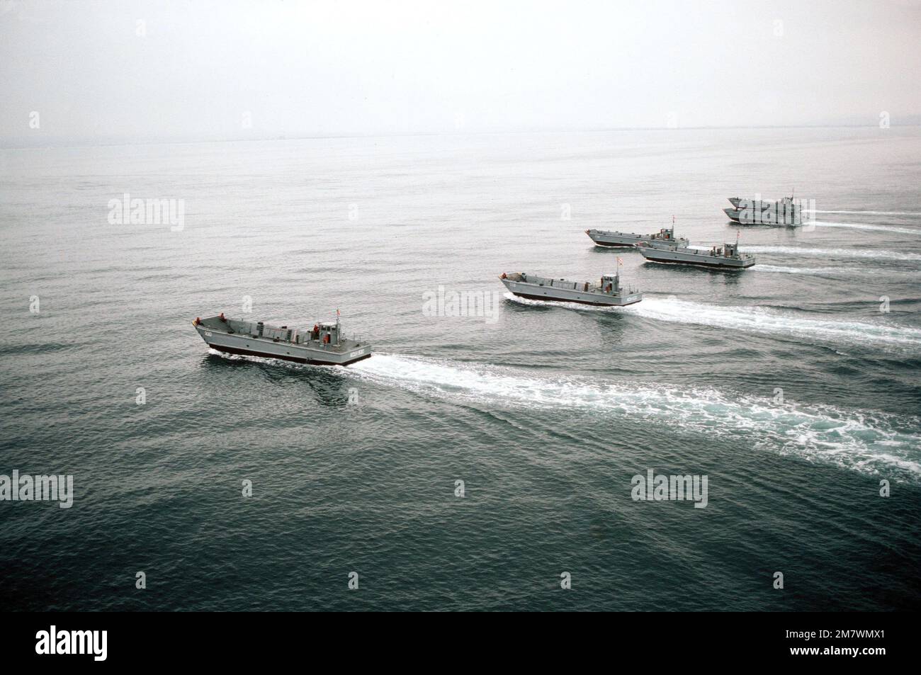 An aerial port quarter view of mechanized landing craft during a ...