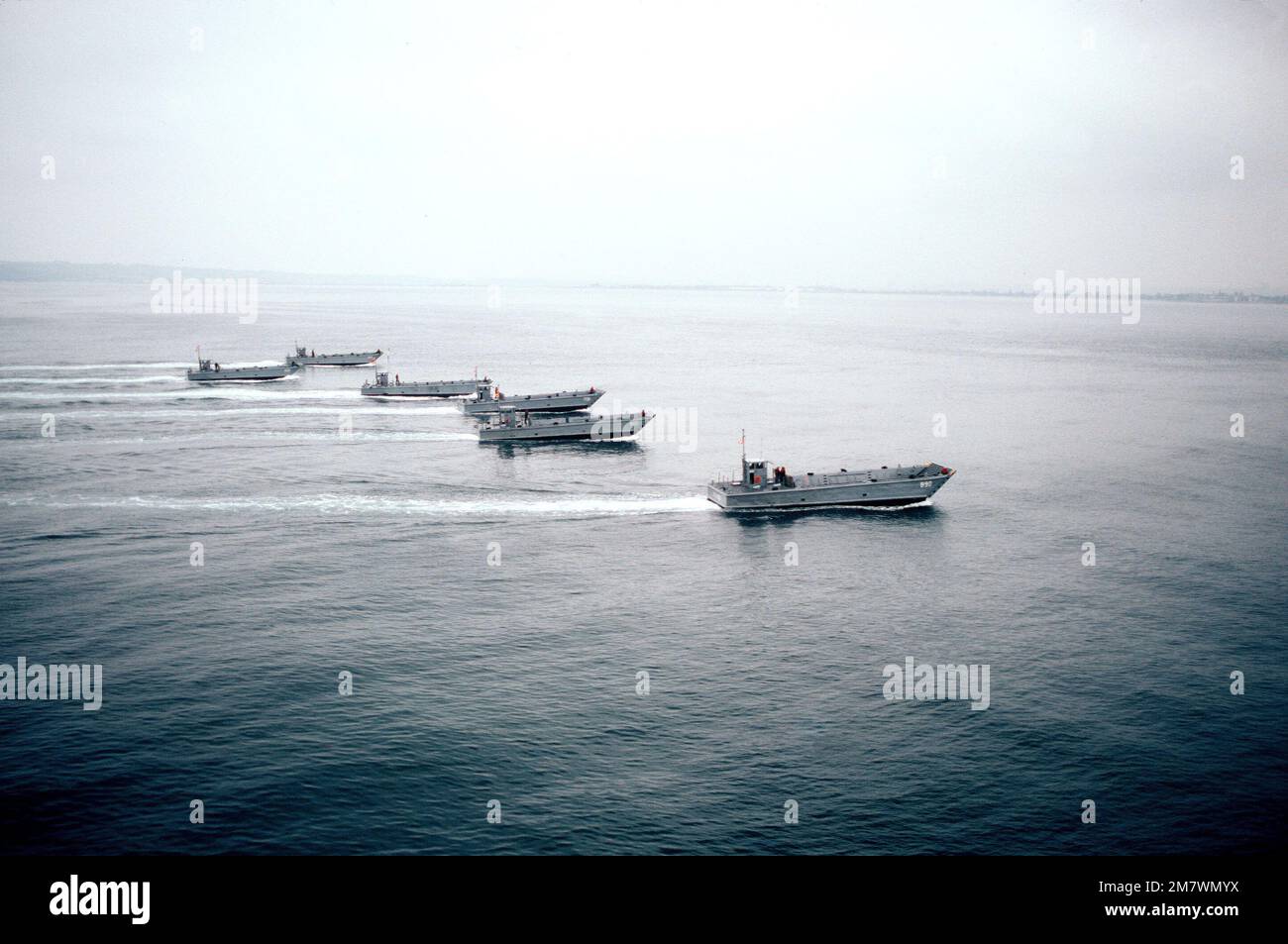 An aerial starboard beam view of mechanized landing craft approaching ...
