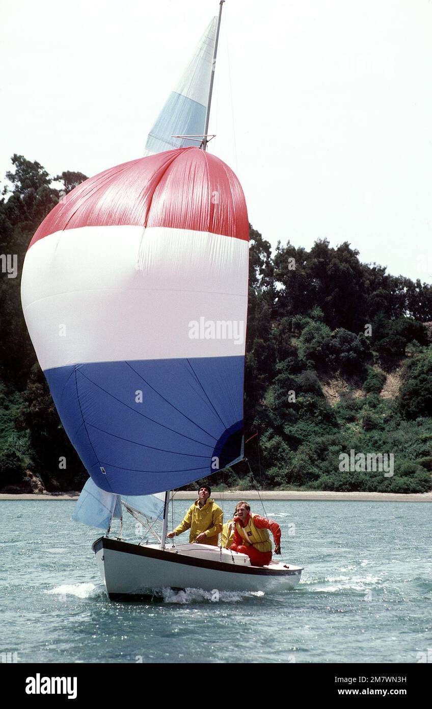 A sailing team lets out the spinnaker during the Treasure Island Yacht ...