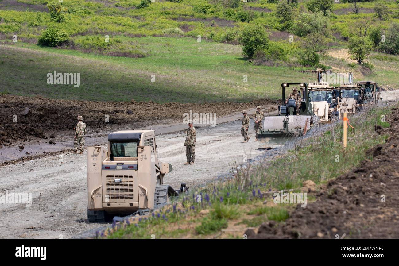 U.S. Army soldiers level soil for infrastructure development on a construction site at Cincu ...