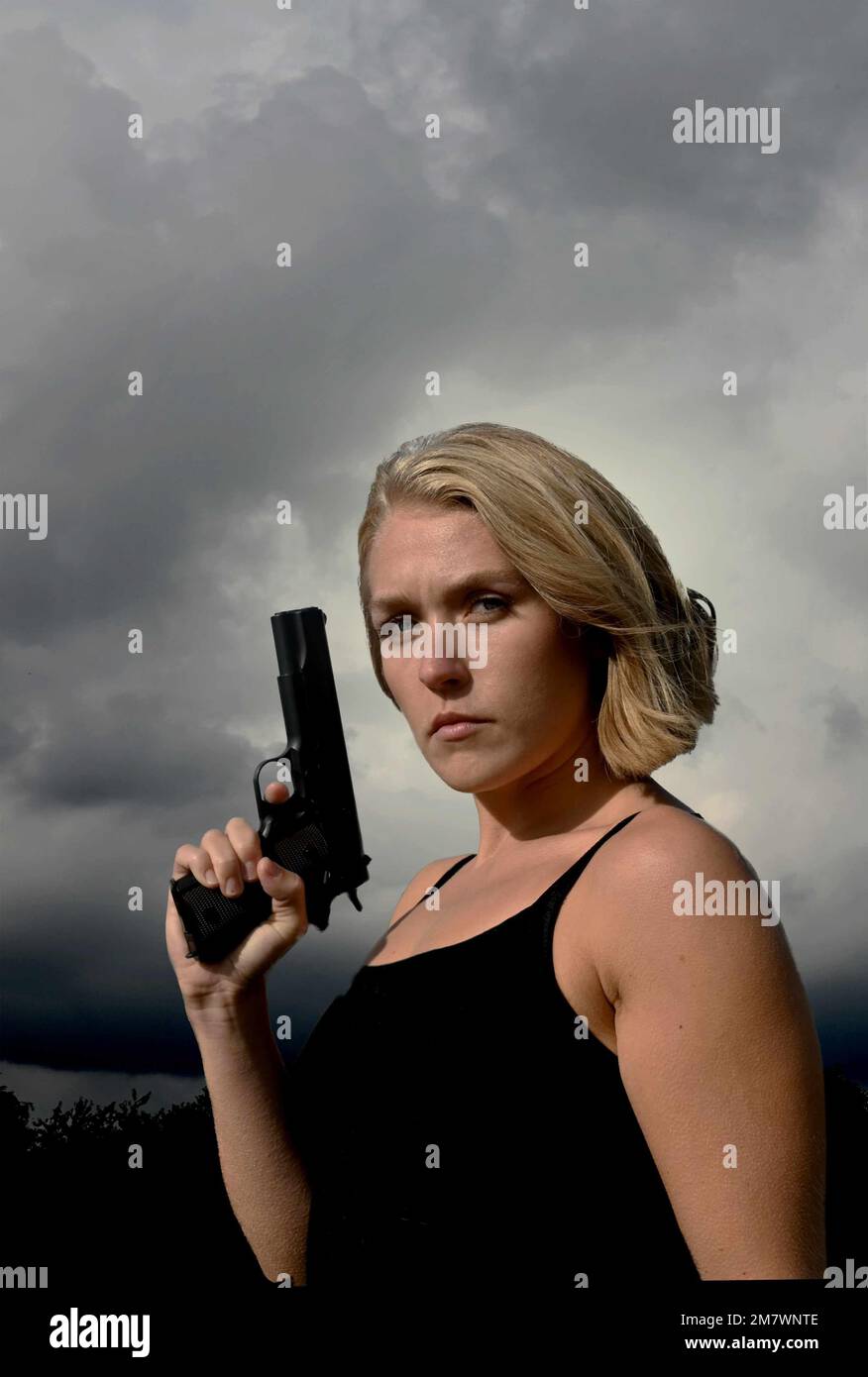 Portrait of young blonde women with gun, detective thriller adventure ...
