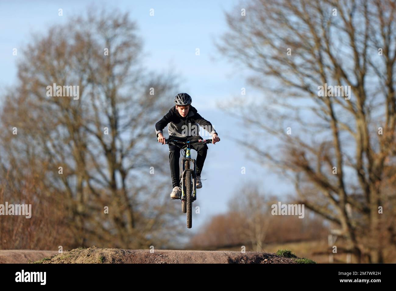 People ride and jump their mountain bikes at a BMX and pump track in ...