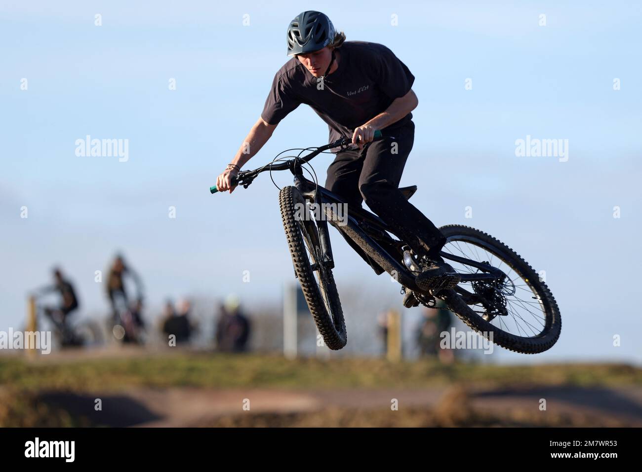 People ride and jump their mountain bikes at a BMX and pump track in ...