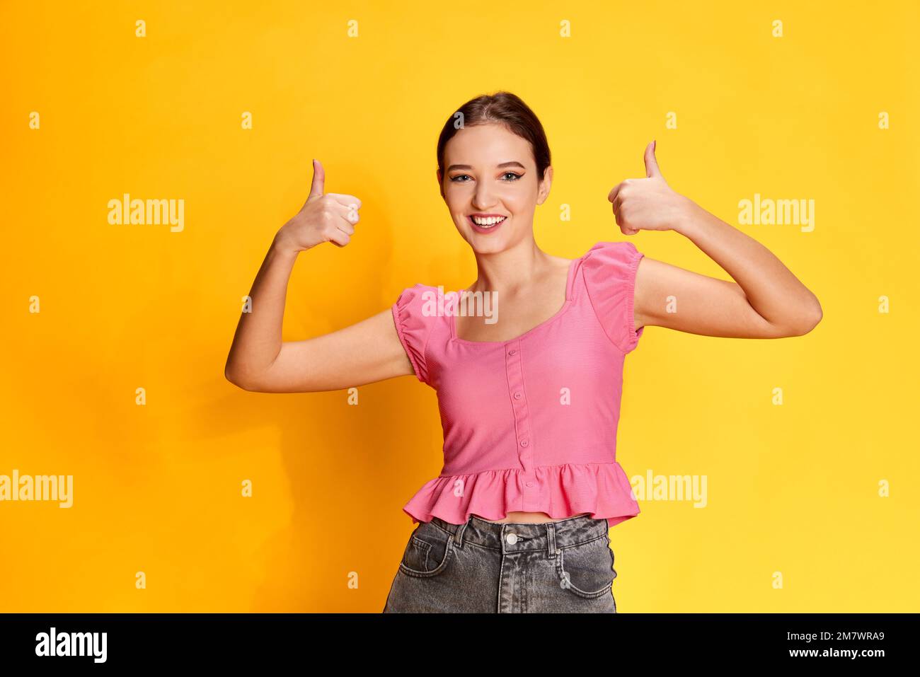 Agreement, approval. Portrait of young beautiful girl posing in pink ...