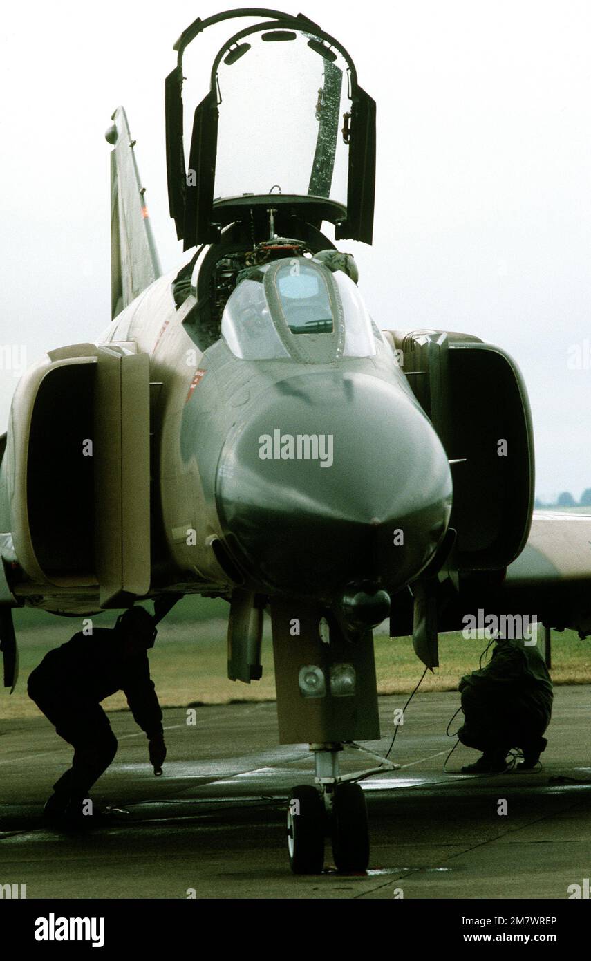 A front view of an F-4D Phantom II aircraft as ground crew personnel ...