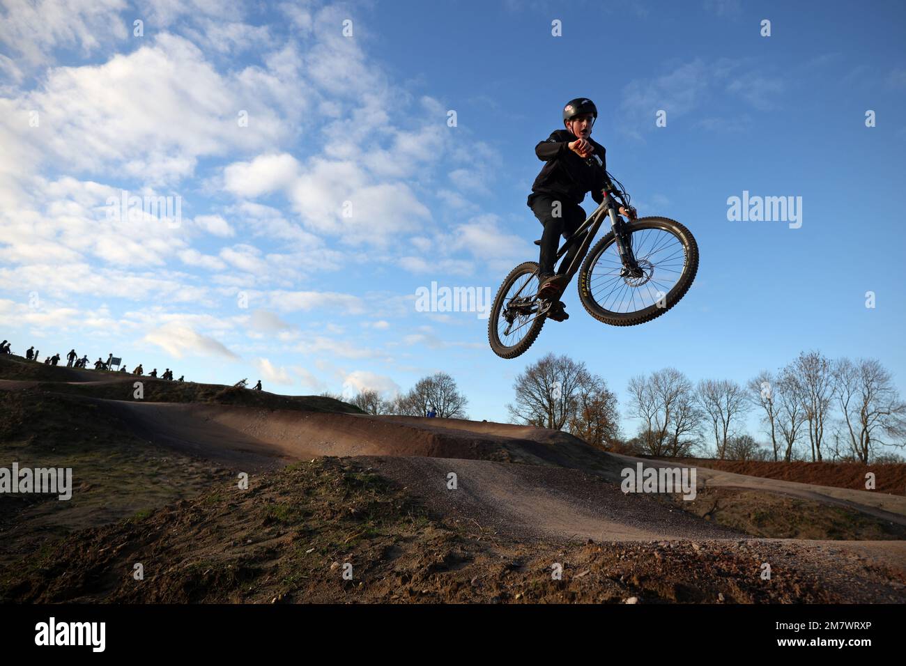People ride and jump their mountain bikes at a BMX and pump track in ...