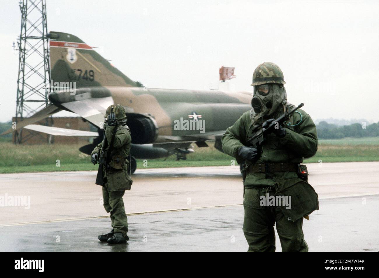 Airmen, armed with M-16 rifles, guard an F-4C Phantom II aircraft ...