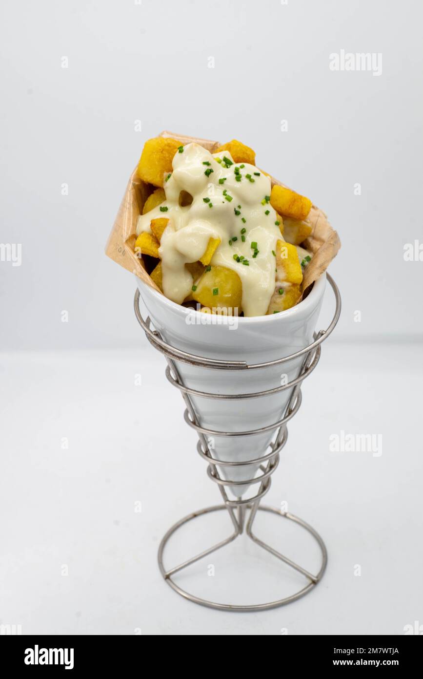 Spanish fries cone with hot sauce, to take away Stock Photo - Alamy