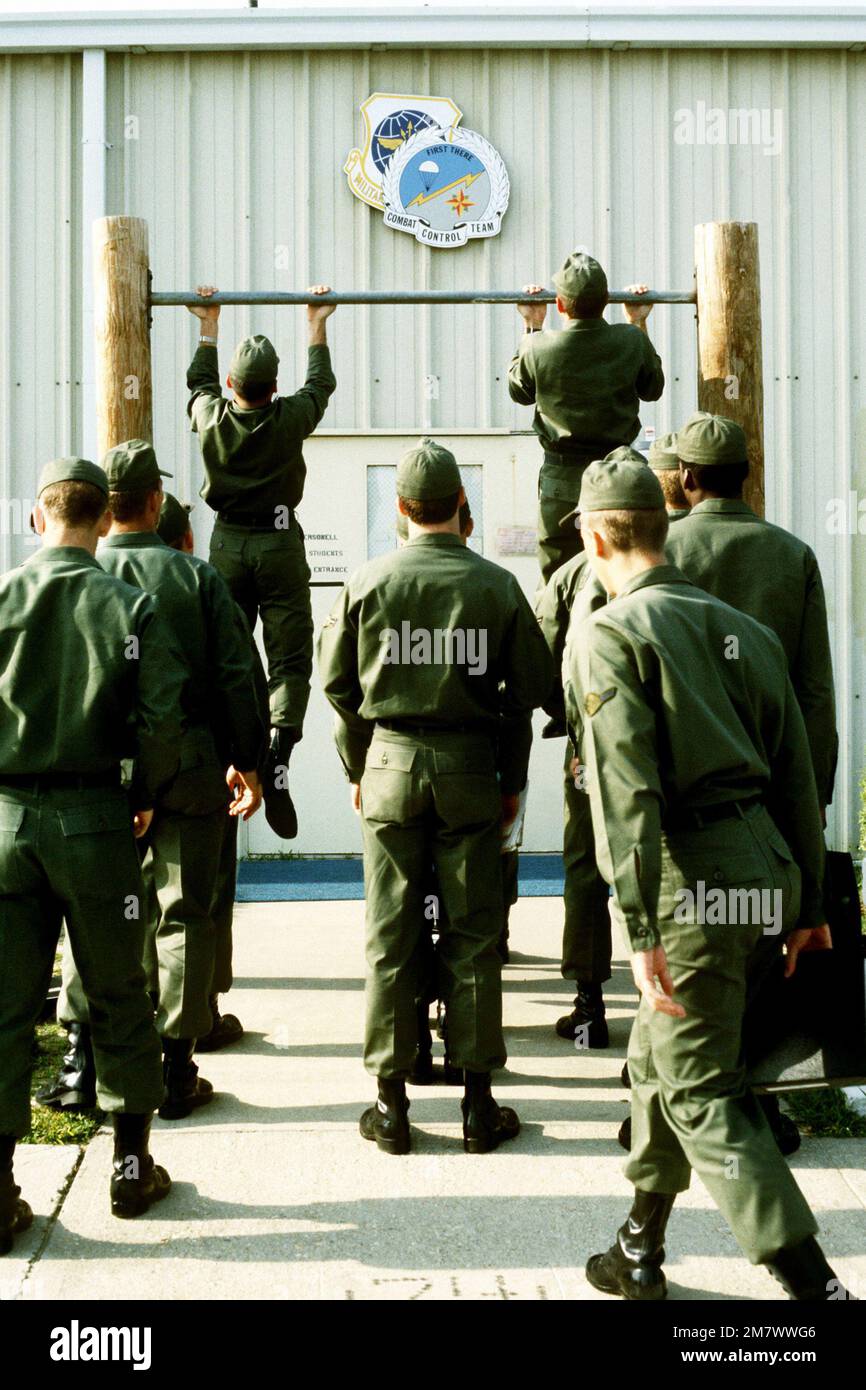 Combat Control School students are doing pull-ups on a chinning bar as ...