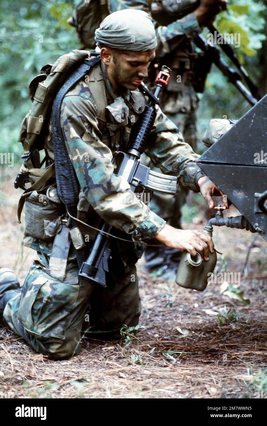 A Combat Control School student, armed with an XM-117 submachine gun ...