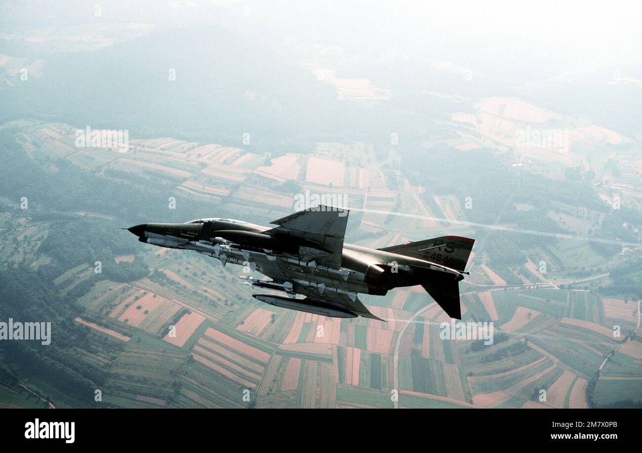 A air-to-air left side view of an F-4E Phantom II aircraft banking to ...