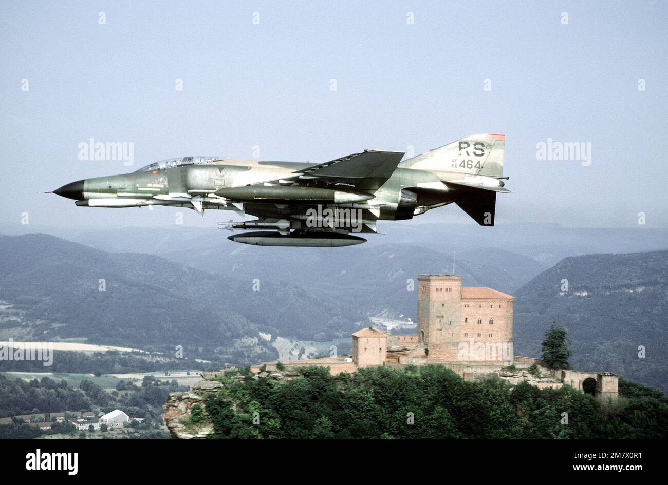 A low angle left side view of an F-4E Phantom II aircraft in flight ...