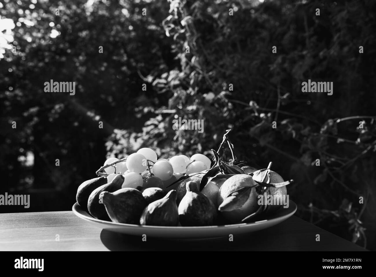 Organic fruits on sunset light on plate outdoor on table of garden ...